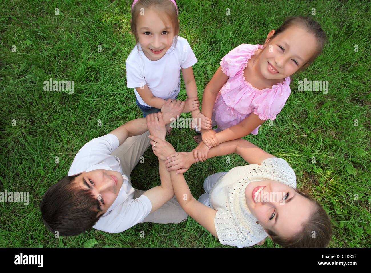 Parents with children stand having joined hands crosswise, top view ...