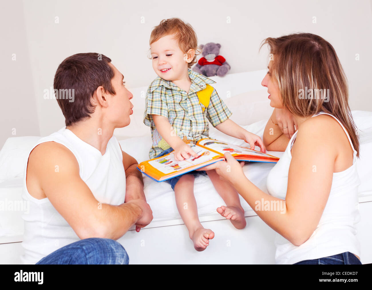 happy family reading a book at home Stock Photo - Alamy