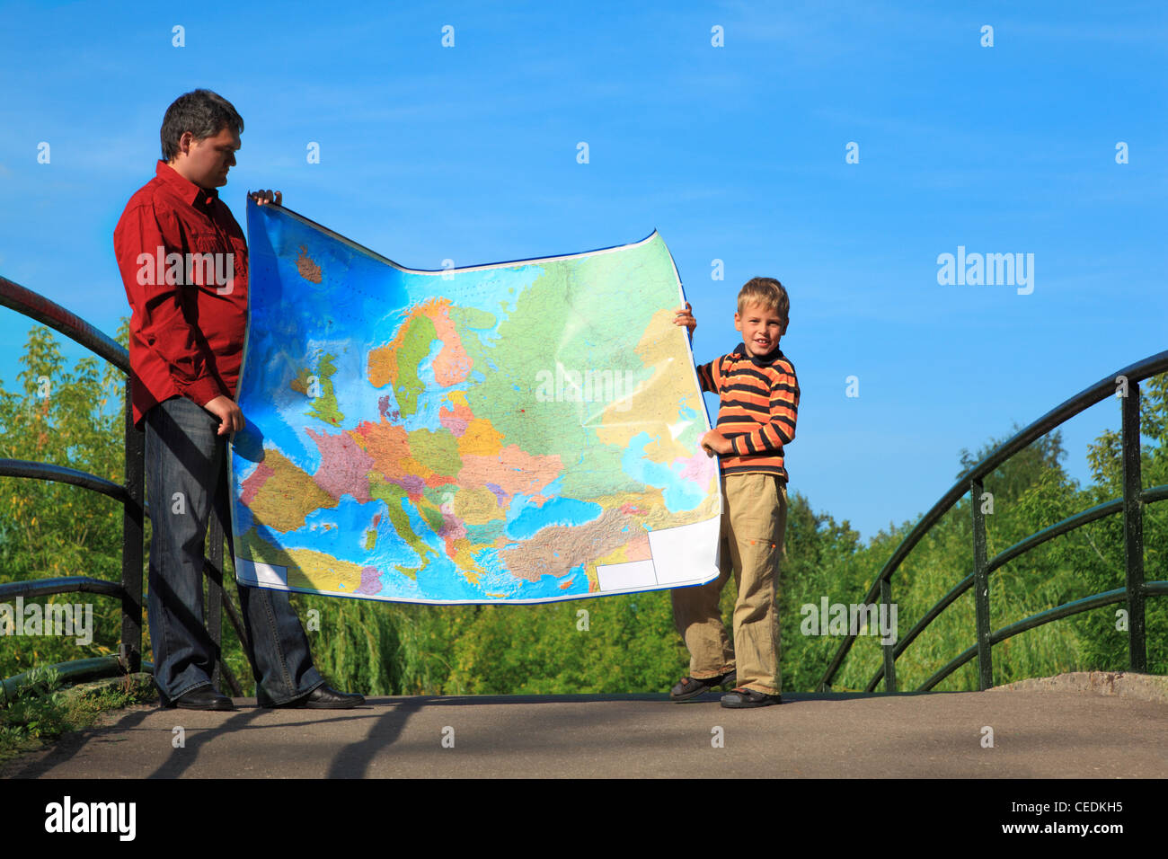 man with boy, they hold in hands expanded map outdoor Stock Photo - Alamy