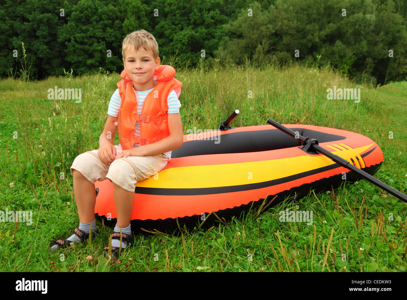 boy sits on an inflatable boat on lawn Stock Photo - Alamy