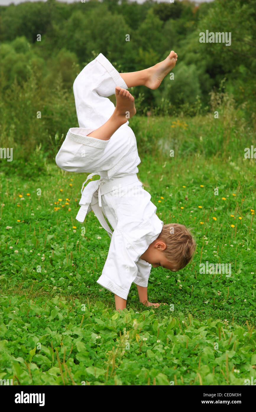 karate boy does handstand on lawn Stock Photo - Alamy