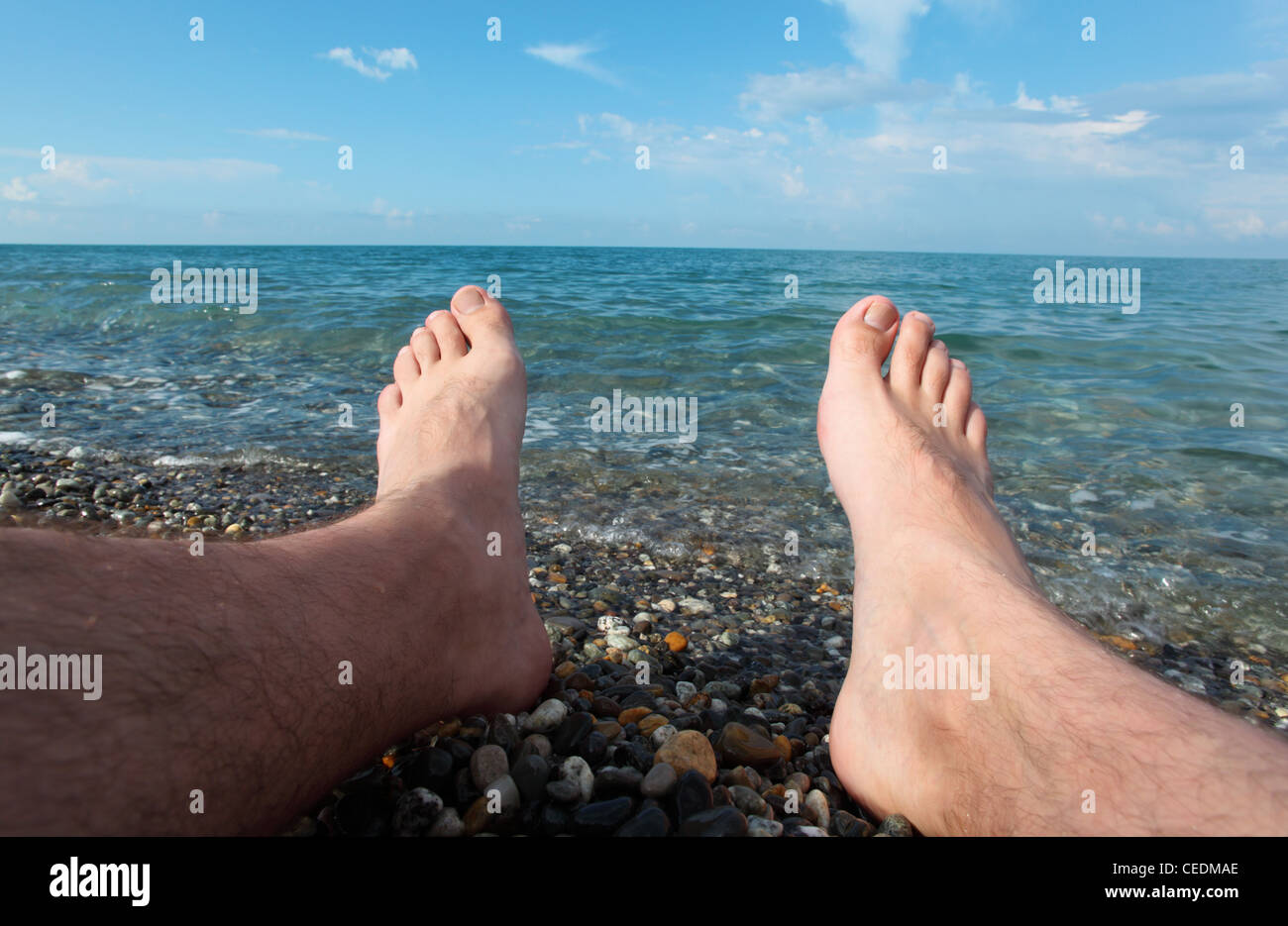 two feet on pebble beach Stock Photo - Alamy