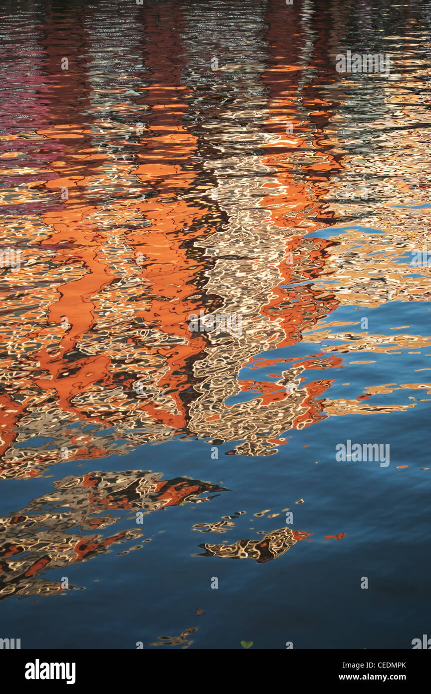 A gently rippled surface on a body of water reflecting blues and golden ...