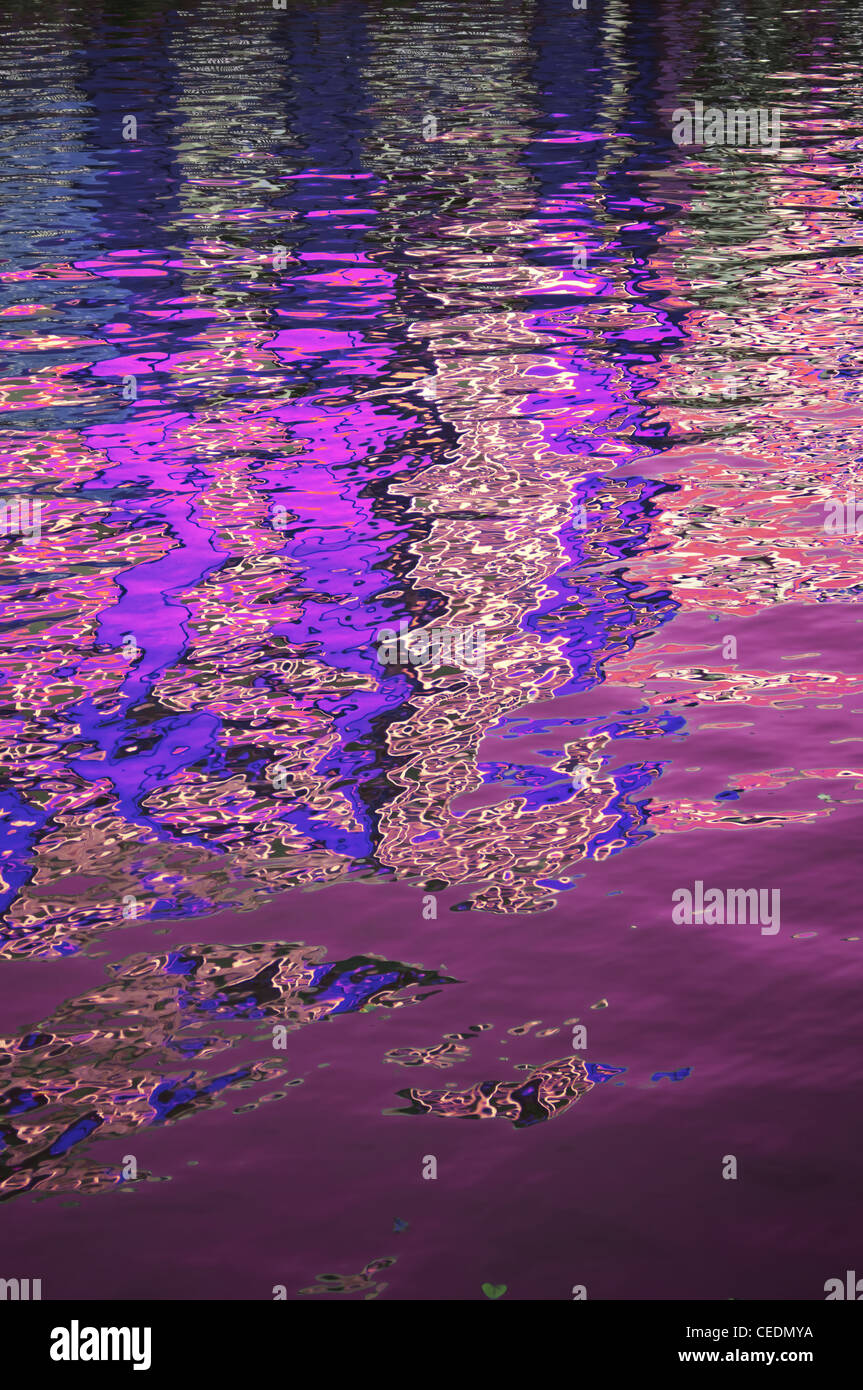 A gently rippled surface on a body of water reflecting blue, pink and ...