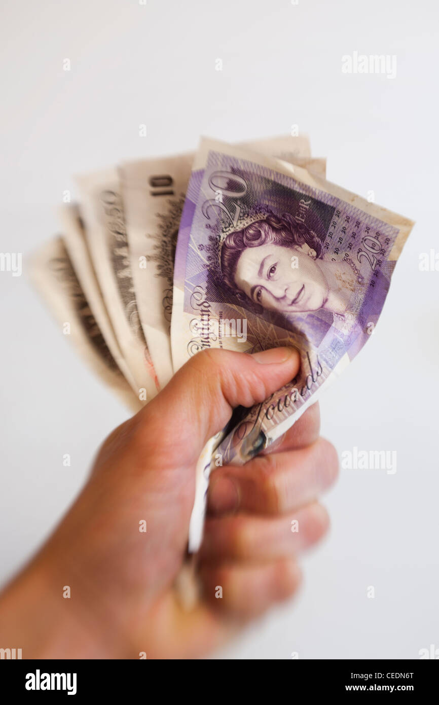 Hand holding a fistfull of twenty pound English currency notes Stock ...