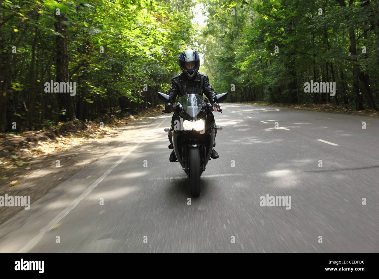 motorcyclist goes on road, front view Stock Photo - Alamy