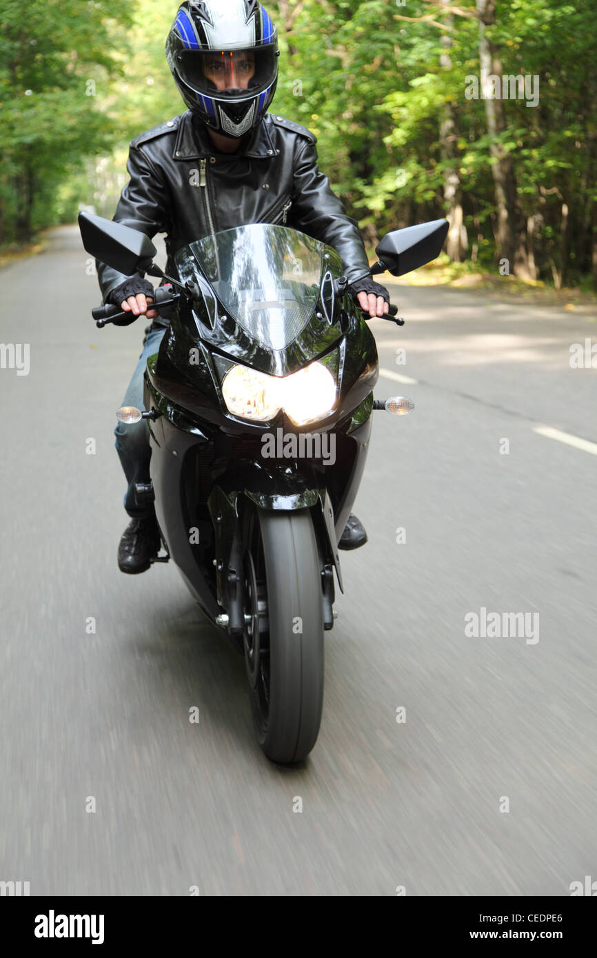 motorcyclist goes on road, front view Stock Photo - Alamy