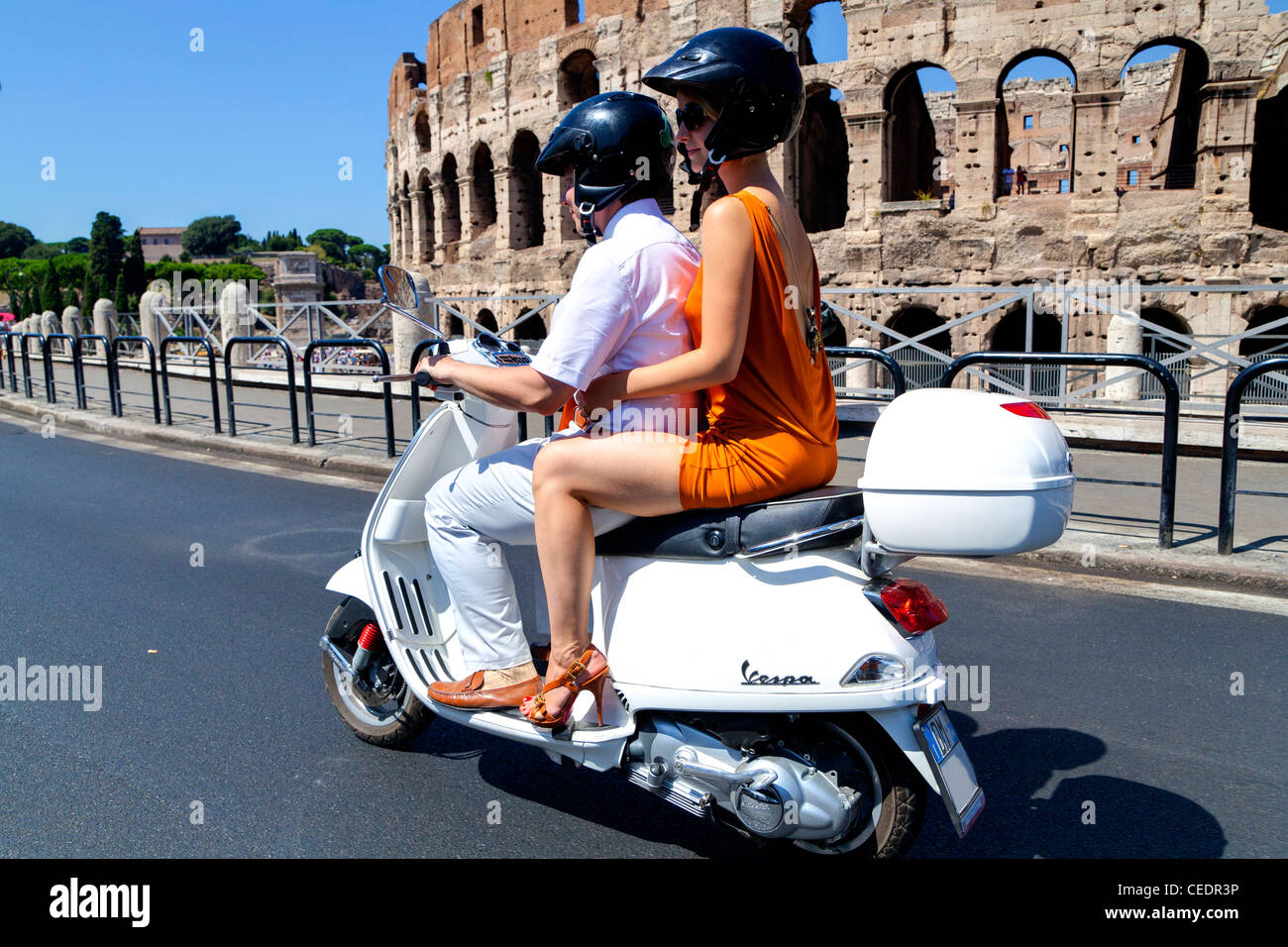 Couple riding a white vespa at the Roman Coliseum Rome Italy Stock ...