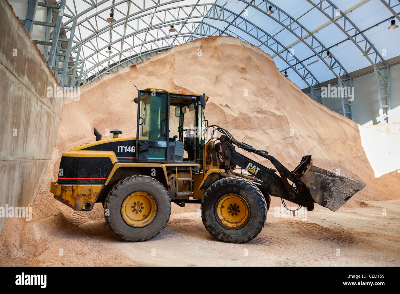 Road grit store with mechanical shovel or digger Stock Photo - Alamy