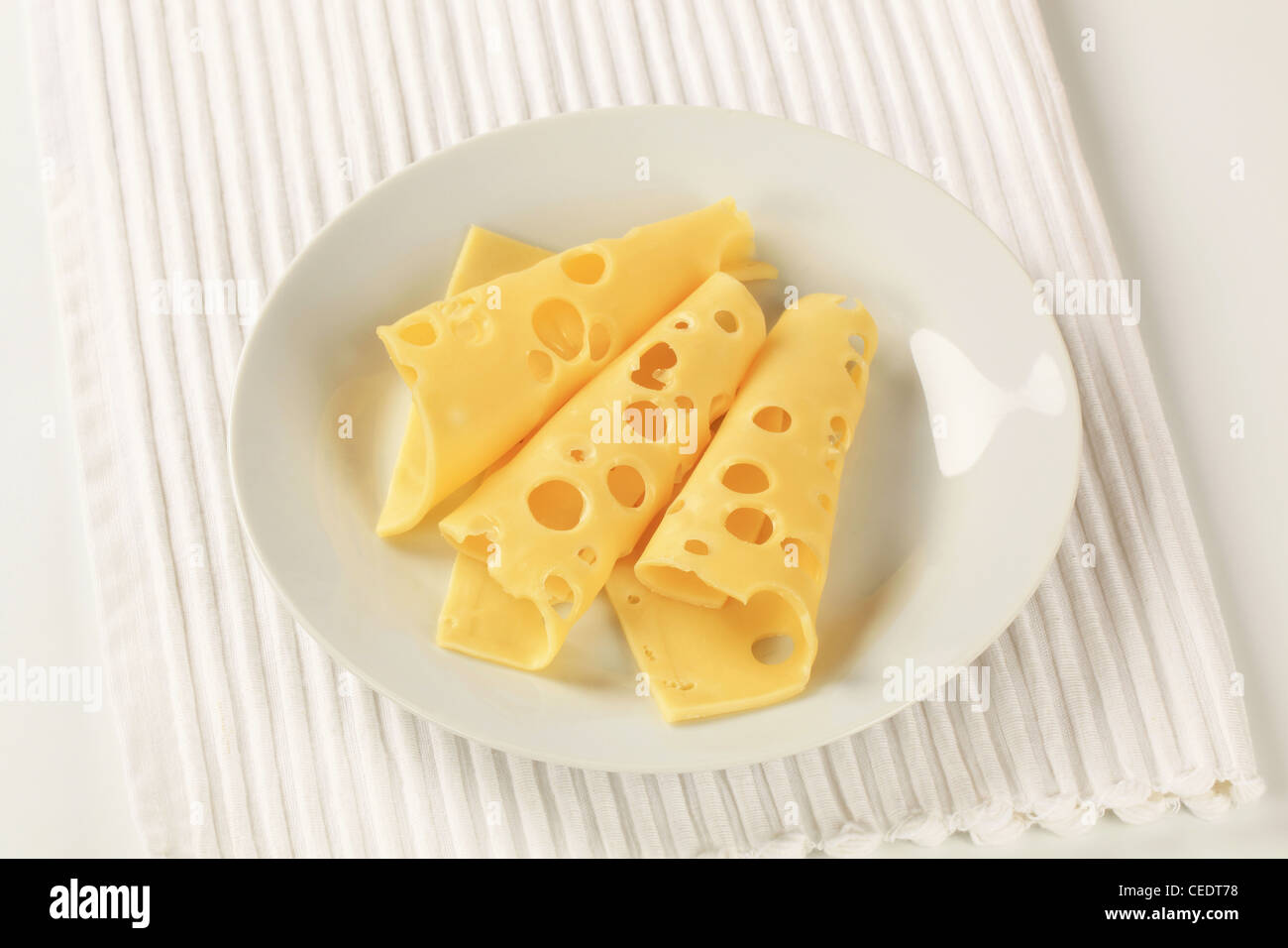 Thin slices of Swiss cheese on a plate Stock Photo - Alamy