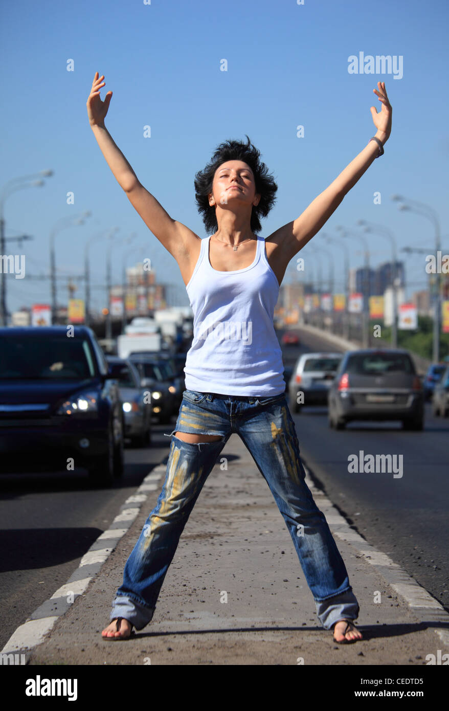 girl stands on middle of road with rised hands Stock Photo - Alamy