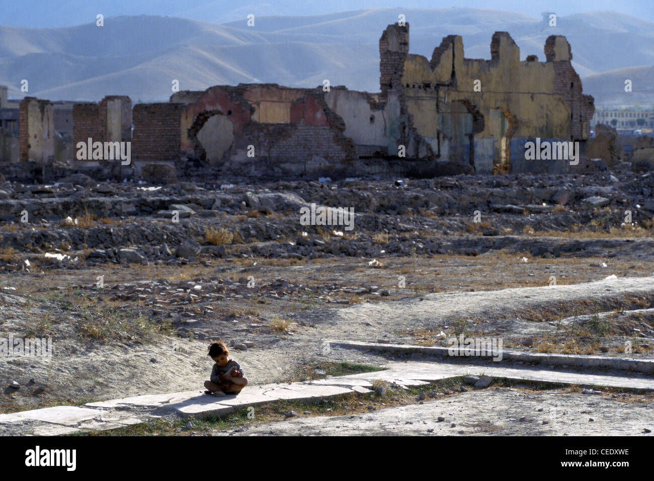 A refugee child who lives with her family in nearby ruins, plays in the ...