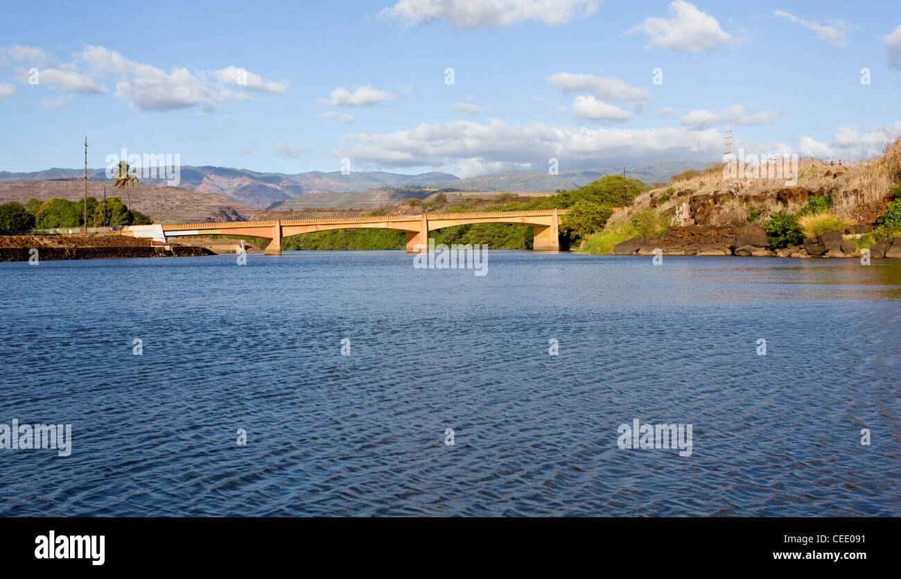 River Waimea flows under road bridge at estuary with canyon in distance ...