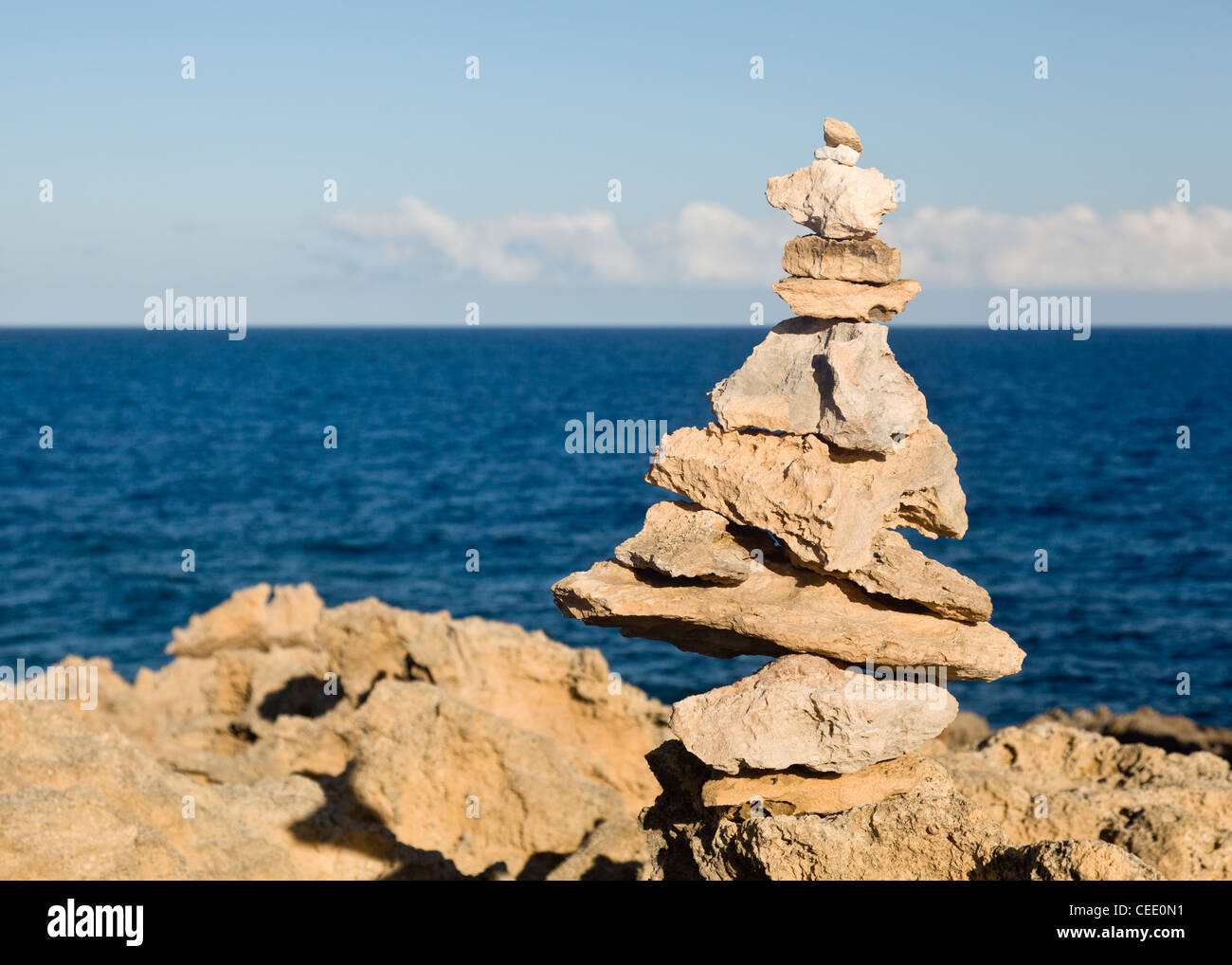 Pyramid shaped stack of rocks balanced on the edge of ocean Stock Photo ...