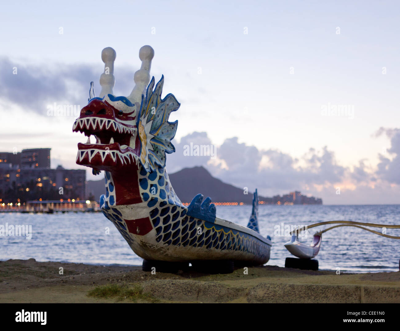 Dragon shaped head on traditional canoe on sand in Waikiki with Diamond ...