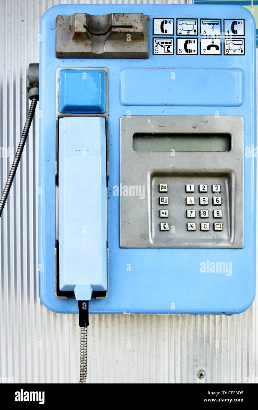 Blue public telephone close-up on the wall Stock Photo - Alamy