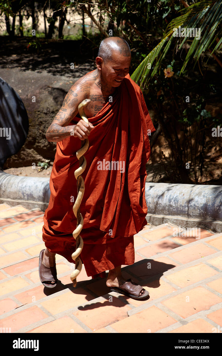 happy Buddhist monk climbing stairs in cambodia with walking stick ...
