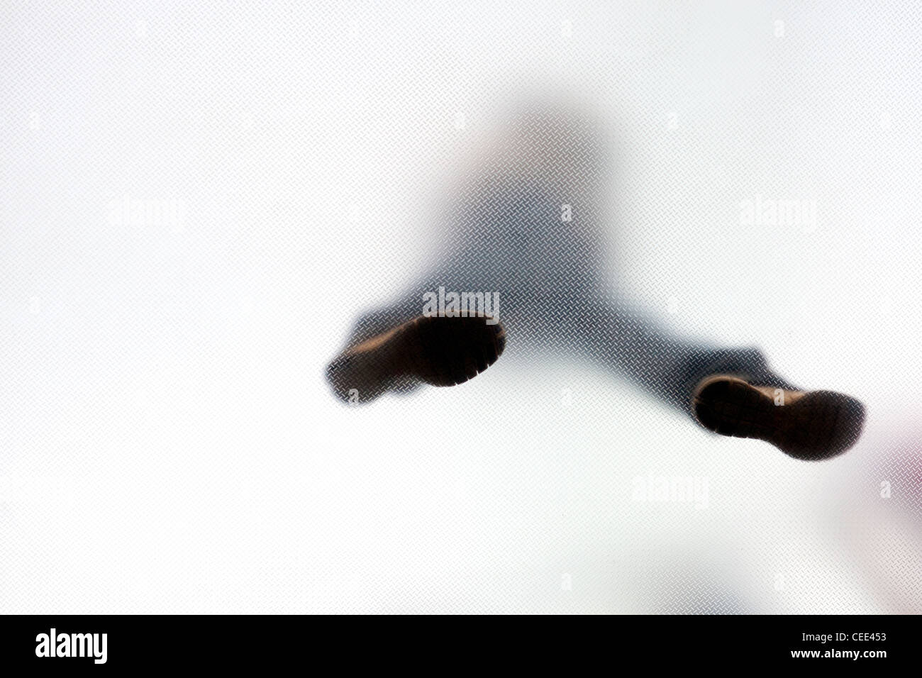 A bottom underside view of people walking across a translucent opaque ...