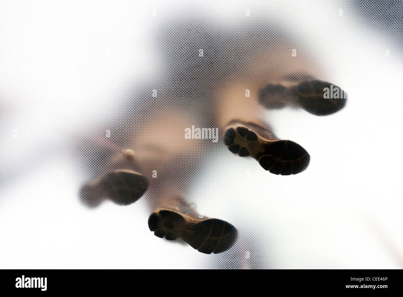 A bottom underside view of people walking across a translucent opaque ...