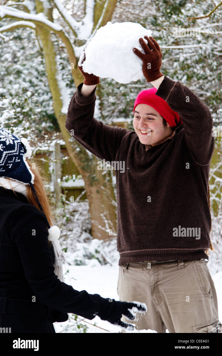 Young man holding a large snowball above his head Stock Photo - Alamy