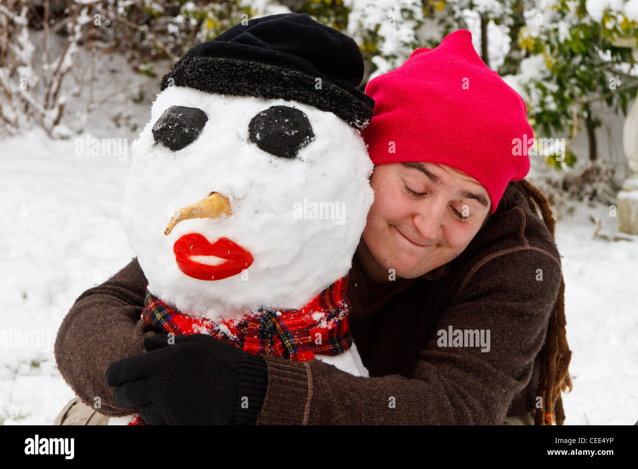Young man hugging a snowman Stock Photo - Alamy