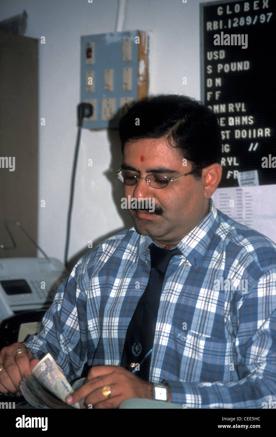 Tika or tilaka mark on the forehead of a currency dealer in India ...