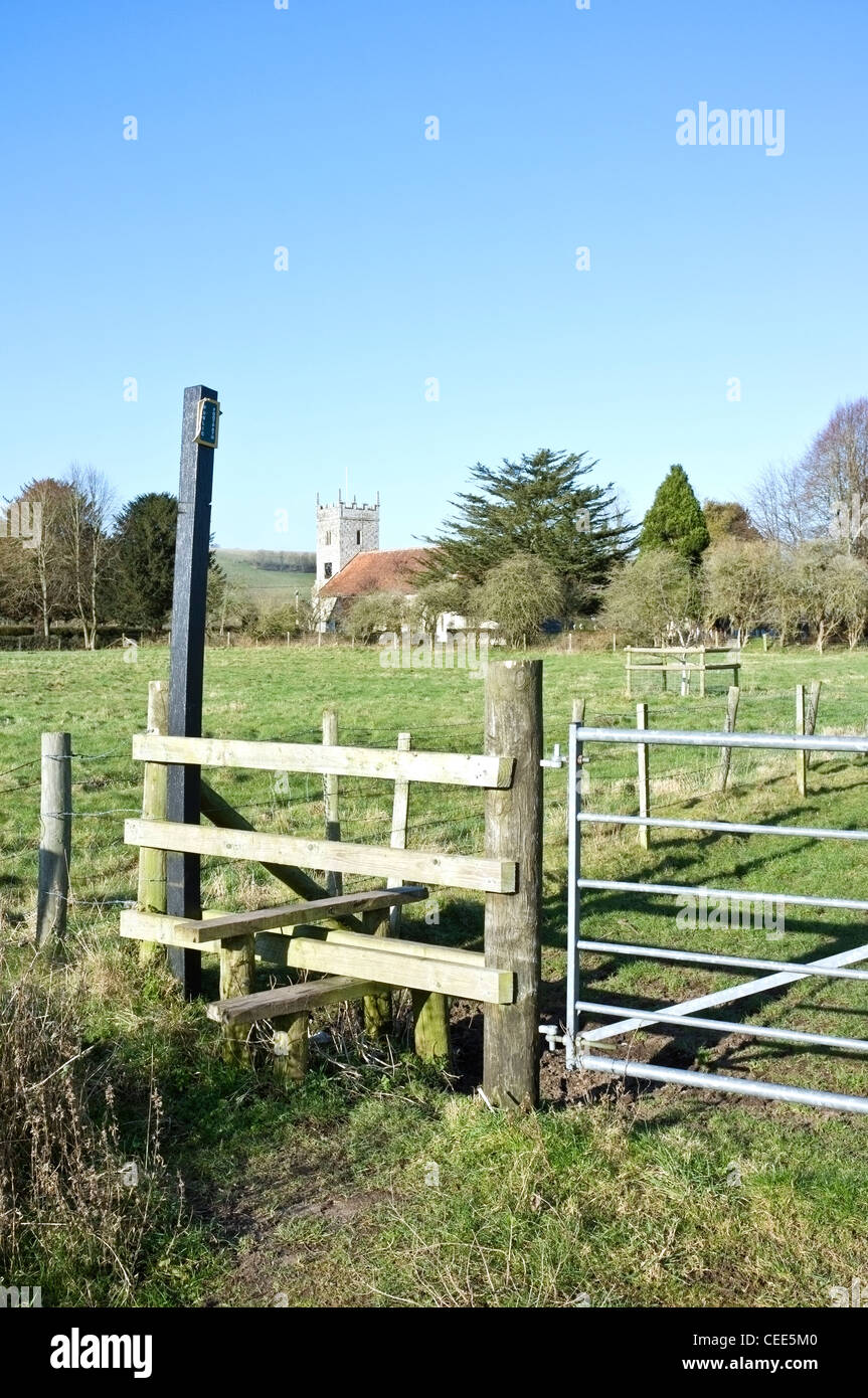 Entrance and stile to a public footpath over farmland with church in ...