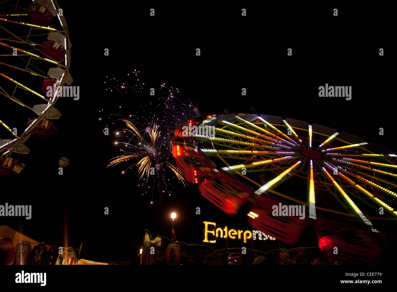 Fireworks are going off while a Ferris Wheel spins at night at a State ...
