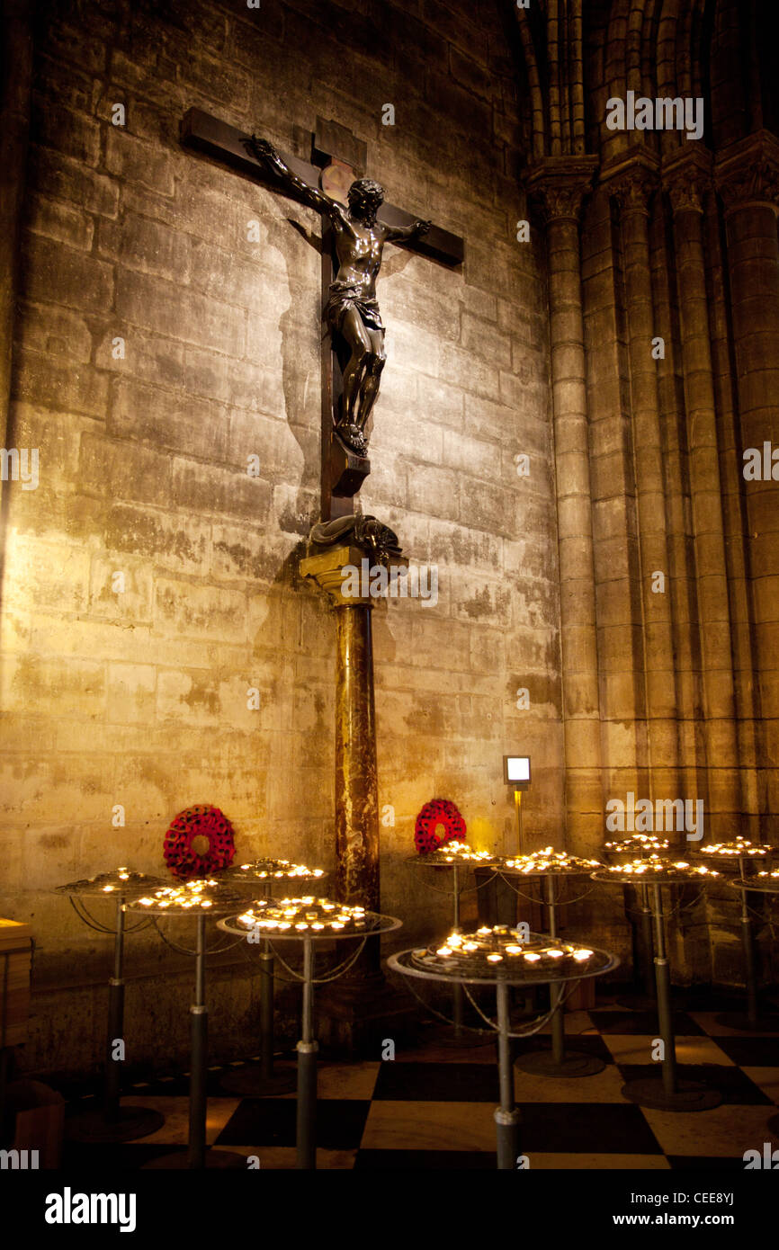 Cross of Christ and burning candles in Notre Dame Cathedral in Paris ...