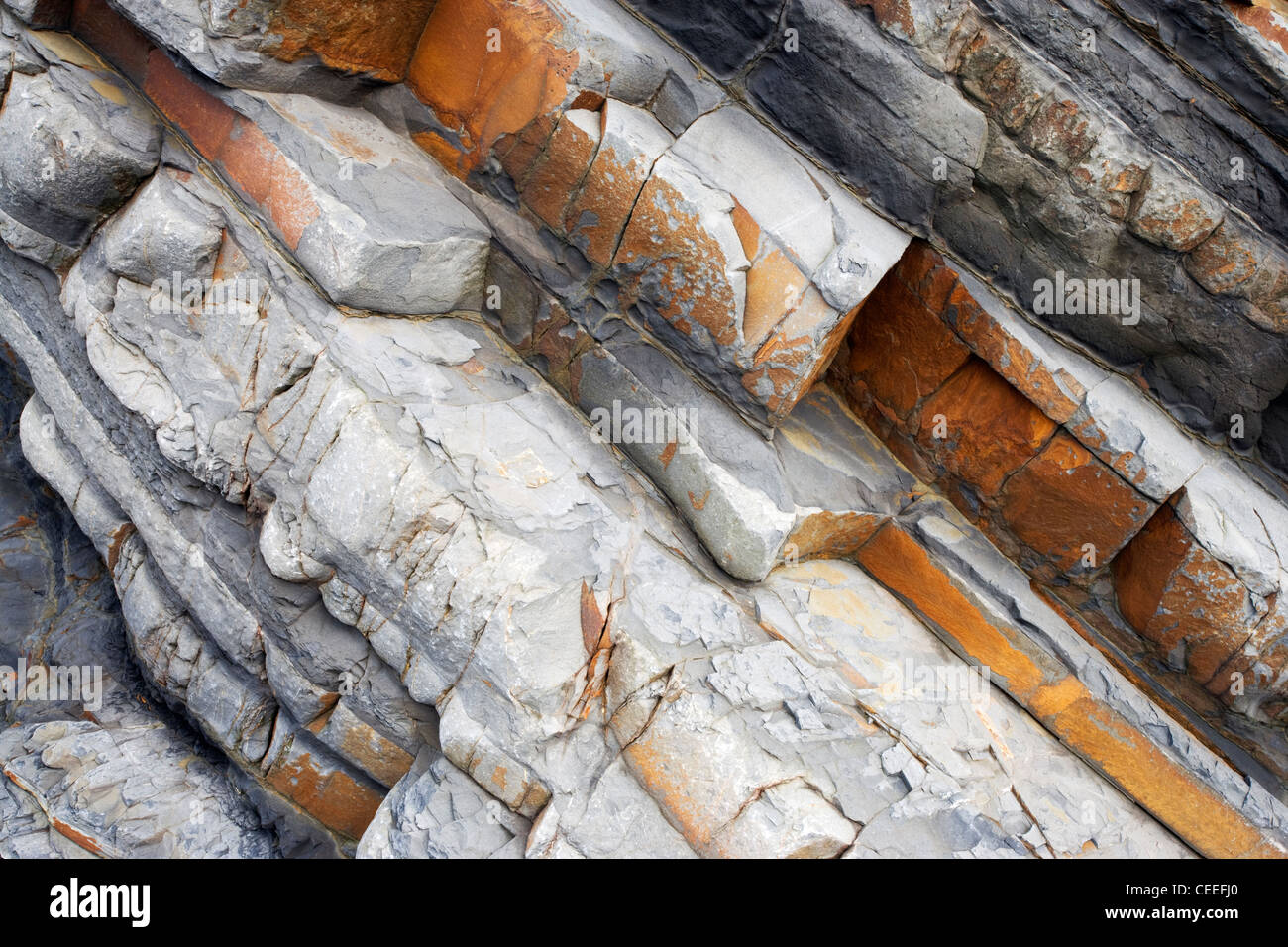 Close up of the colourful rock strata in the cliffs at Sandymouth in ...