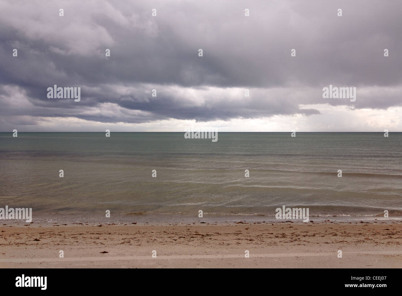 Heavy storm clouds lingering over the eerily calm Atlantic ocean after ...