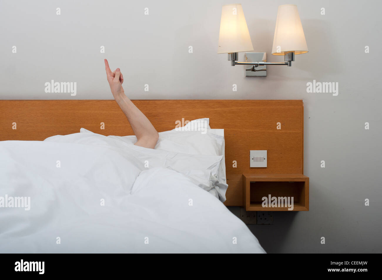 Arm pointing up from under bed covers Stock Photo - Alamy