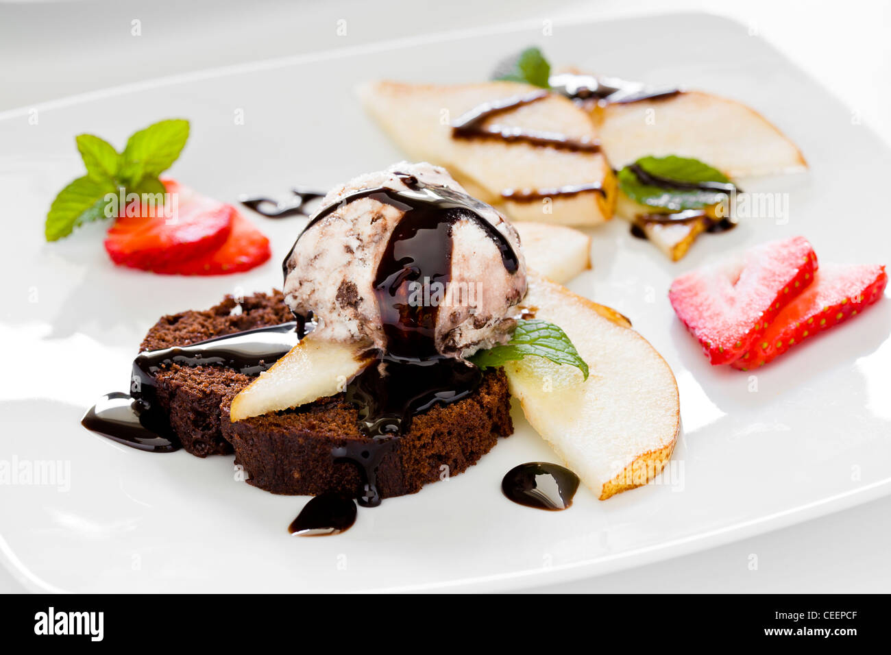 Photograph of a tasty dessert with chocolate cake ice cream and pear ...