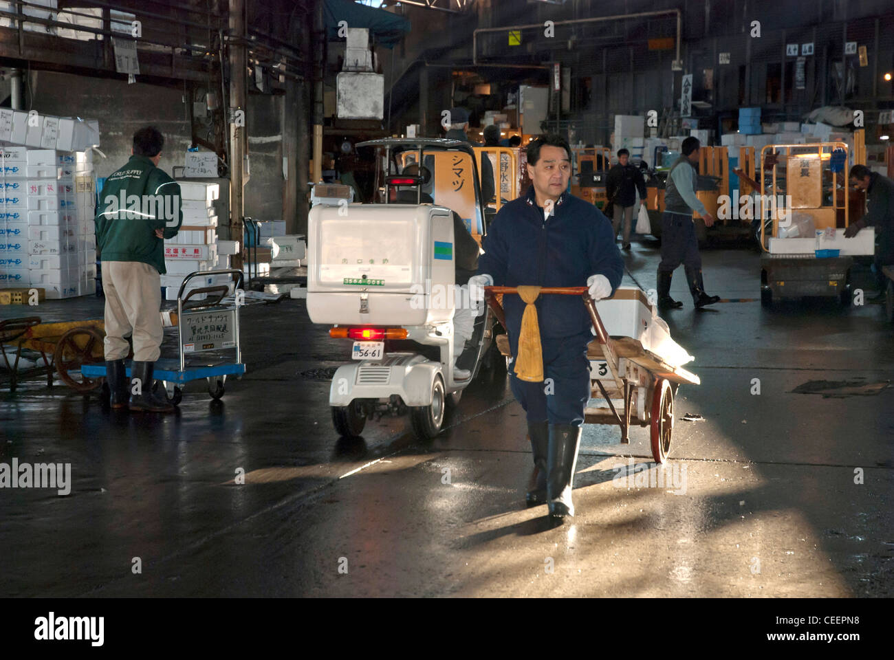 Fishmonger carrying boxes on a cart at Tsukiji market in Tokyo Stock ...
