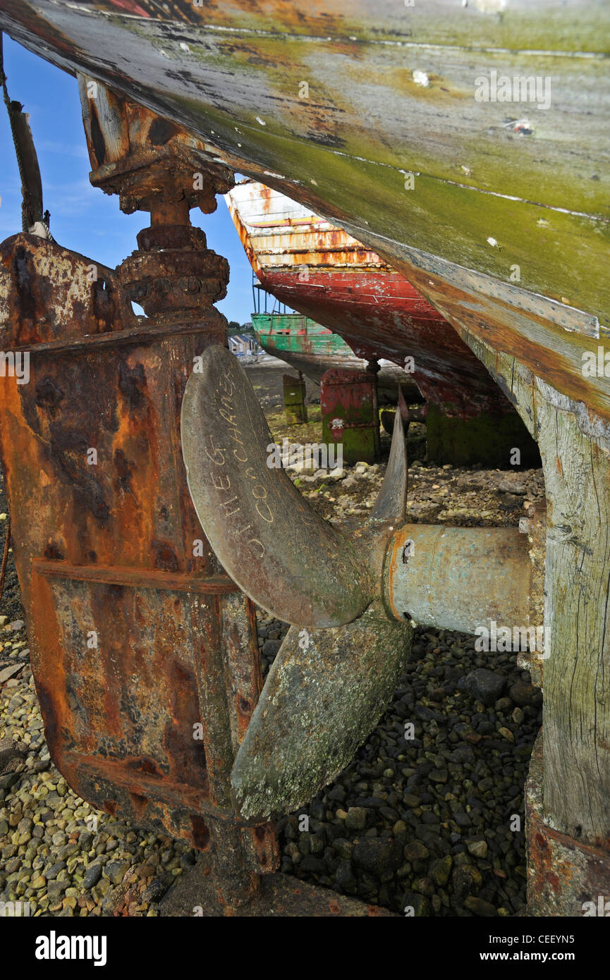 Screw propeller and rudder from wooden wreck of trawler fishing boat in ...