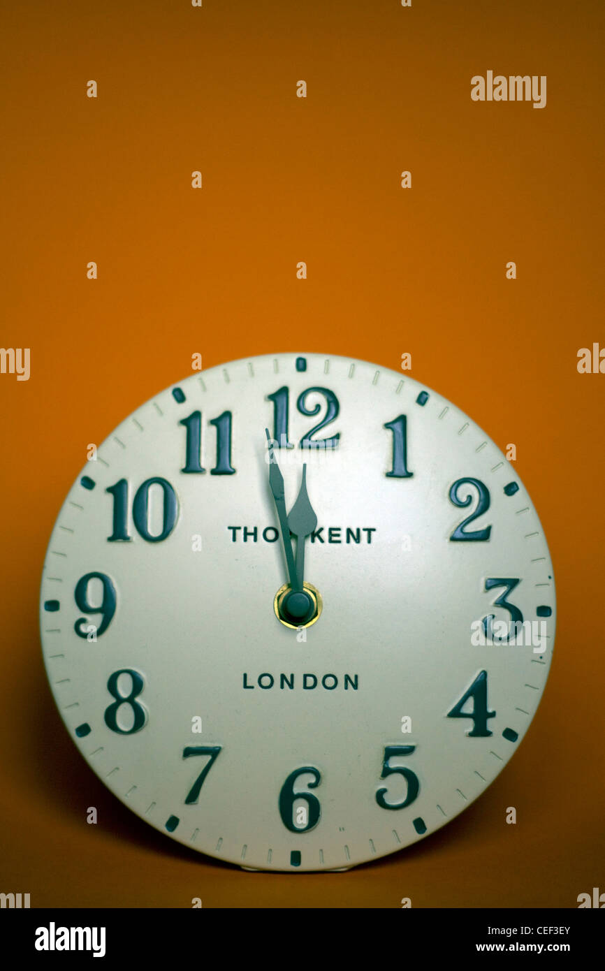 An old-fashioned analogue clock on a plain coloured background reads ...