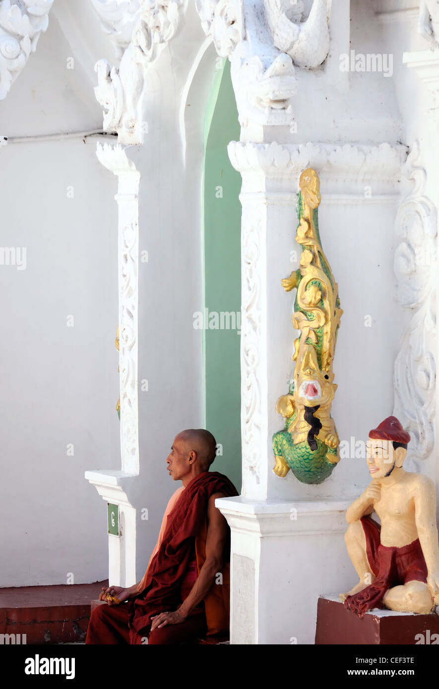 red robed monk contemplate contemplating white stupa buddhist shrine ...