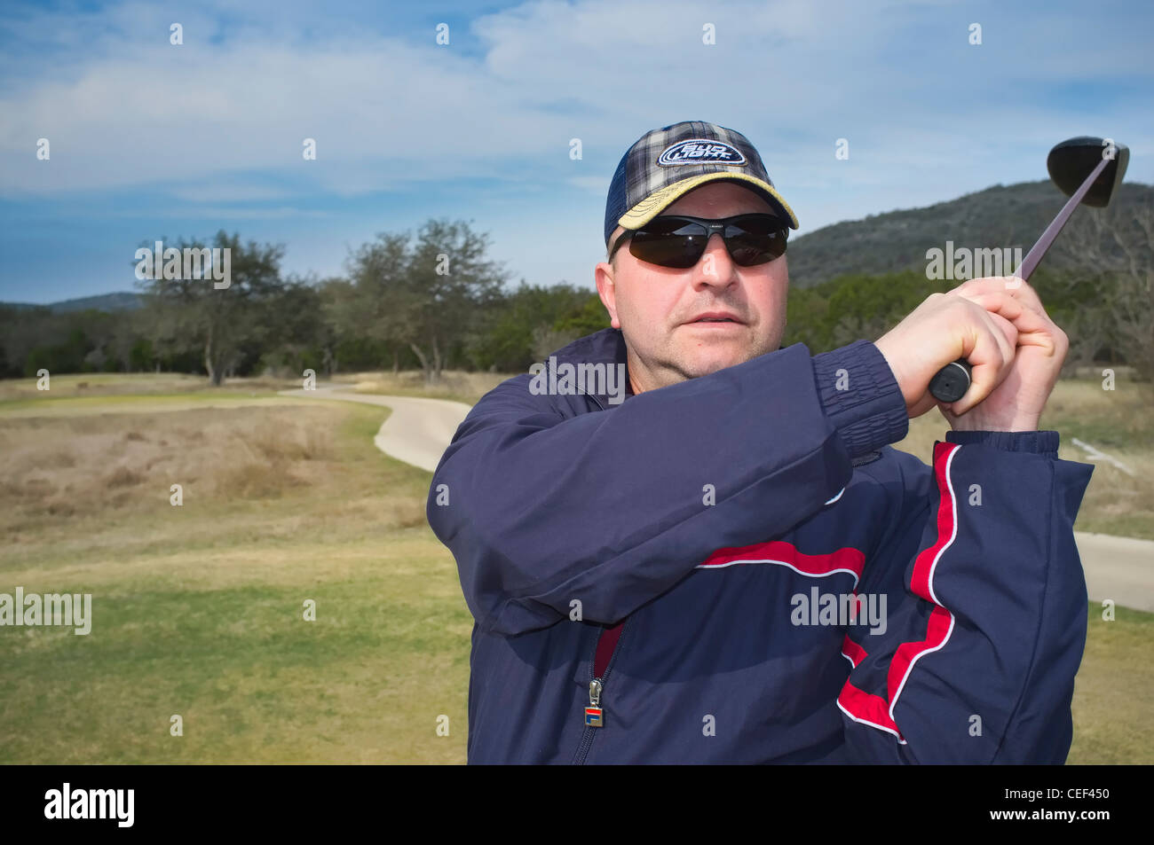 Man with base cap and golf club driver after tee off Stock Photo - Alamy