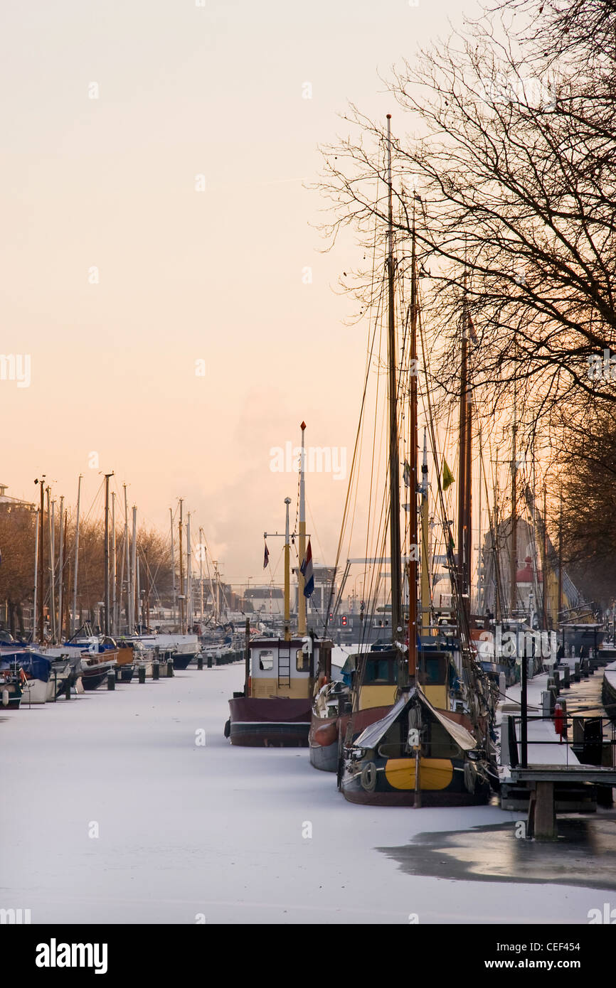 Evening light over snowy and frozen harbour on winter day in january ...