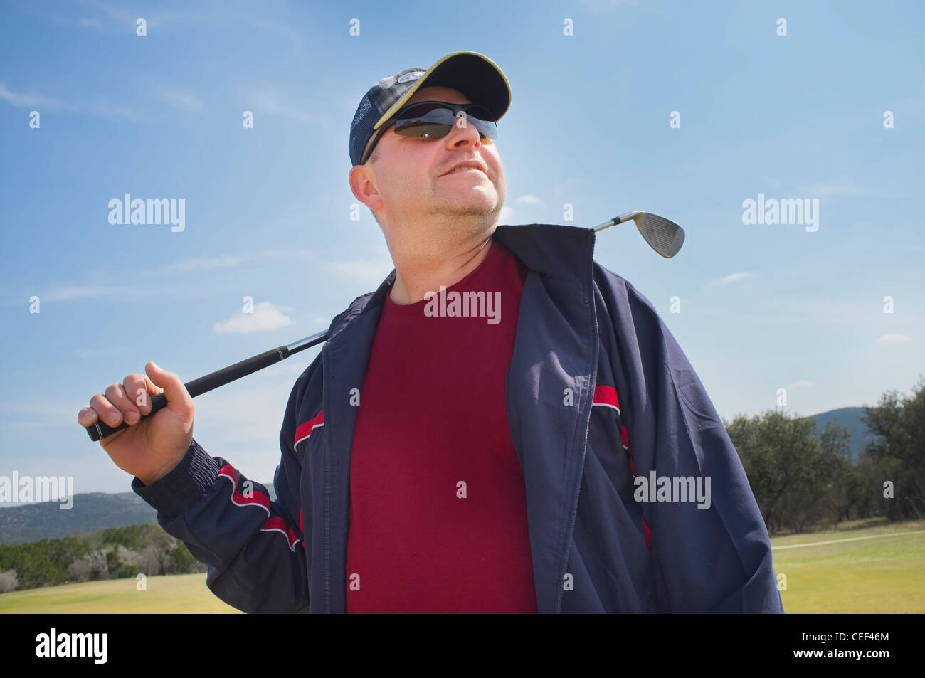Golfer with golf iron watching his ball in flight Stock Photo - Alamy