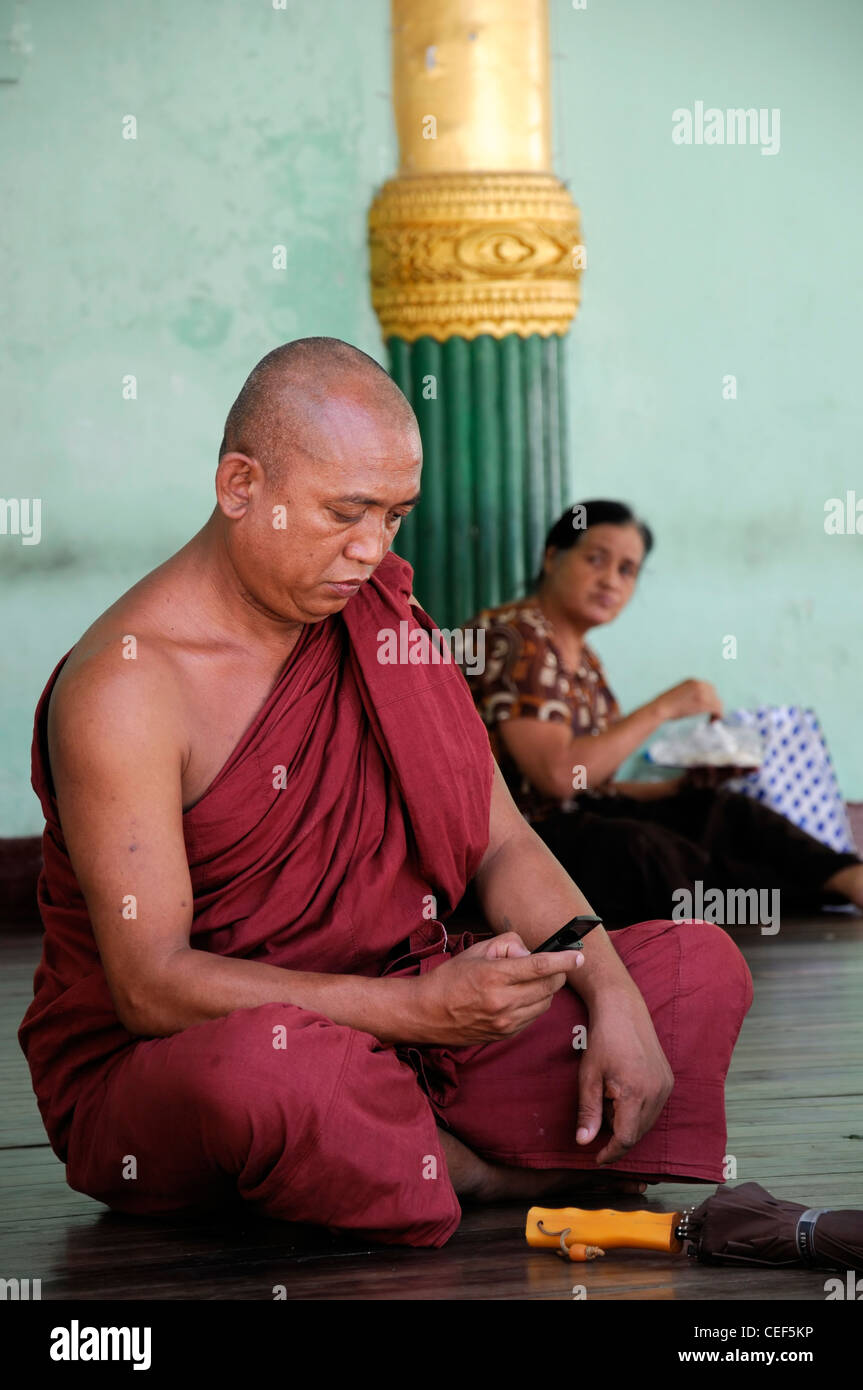 red robed buddhist monk use using text texting mobile phone Shwedagon ...
