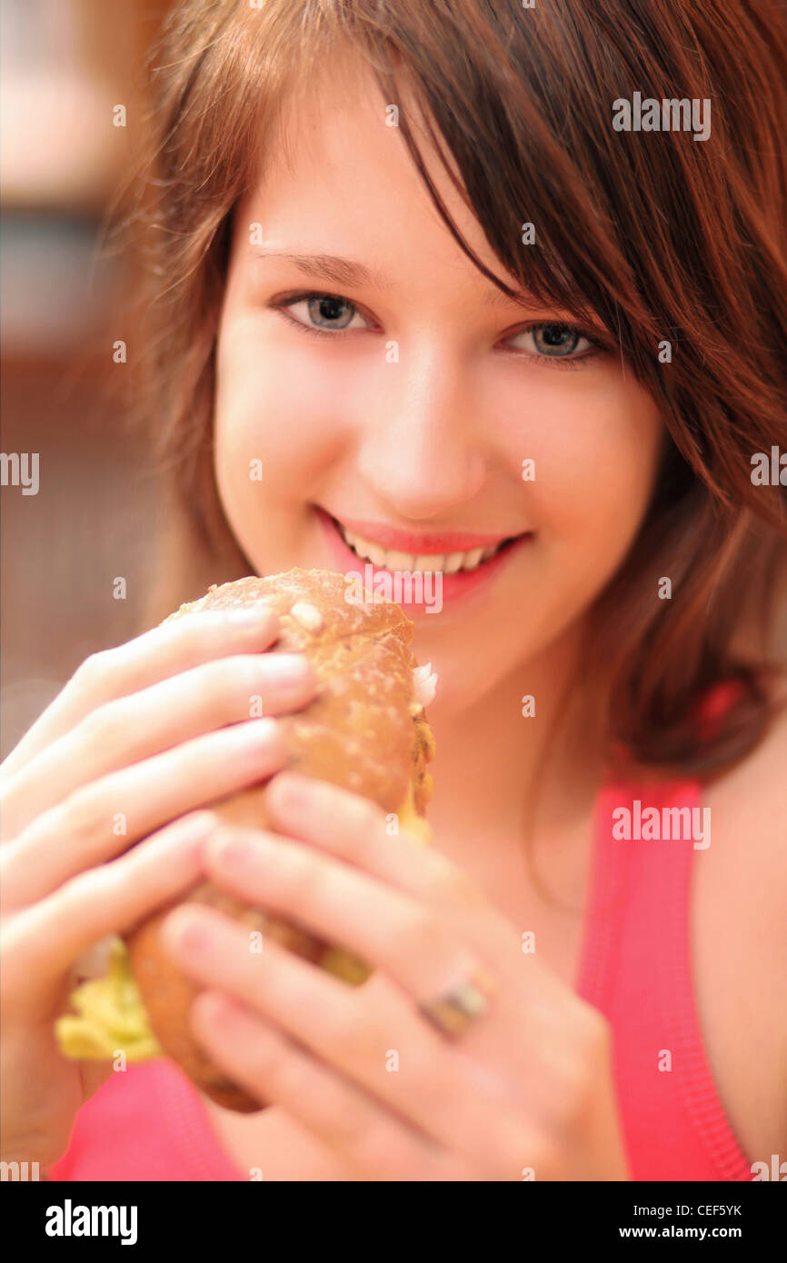 Teenage girl is eating sandwich Stock Photo - Alamy
