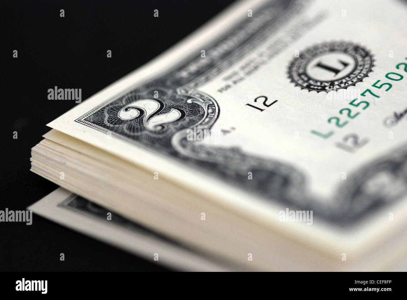 A close up of a stack of new USD two dollar bills. On black backround ...