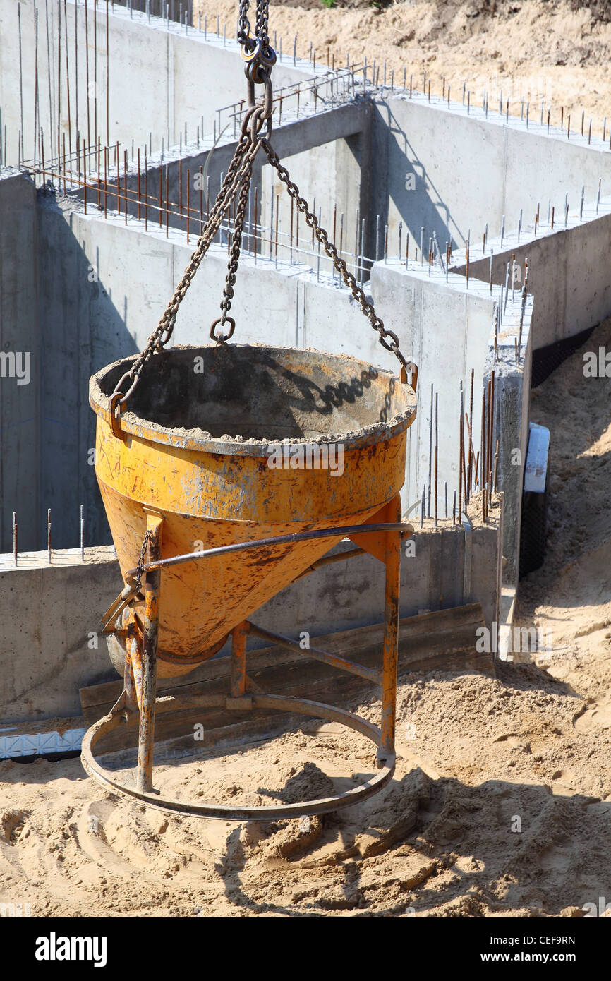 digger, excavator construction building site pouring concrete in form ...