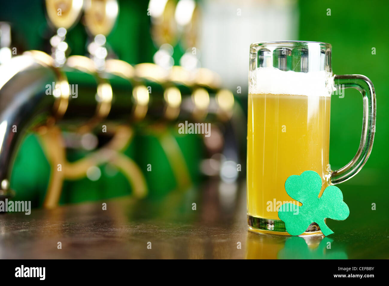 A glass of beer on a bar counter with a leaf of shamrock Stock Photo ...