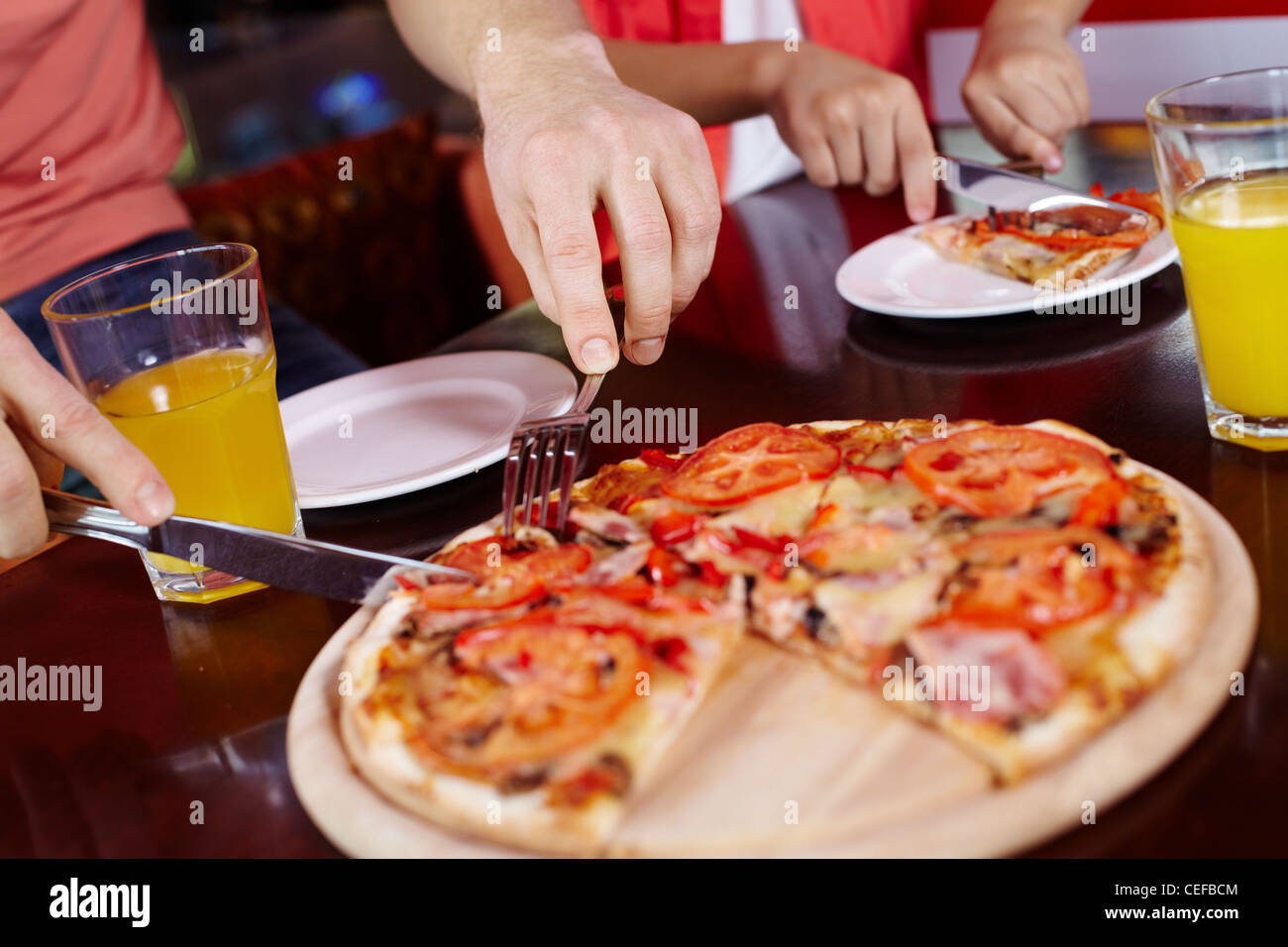 Someone cutting pizza in pieces Stock Photo - Alamy