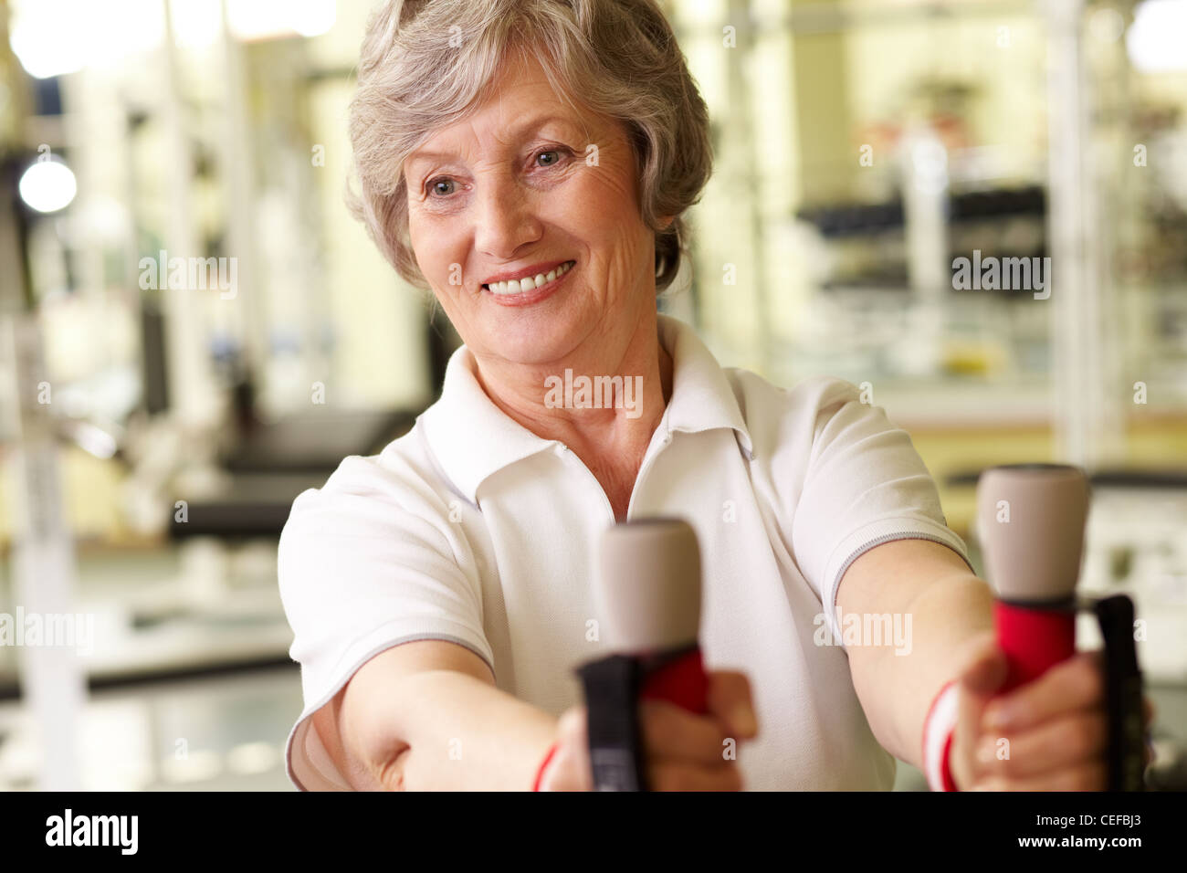 Tilt up of a pretty mature lady working out at gym Stock Photo - Alamy