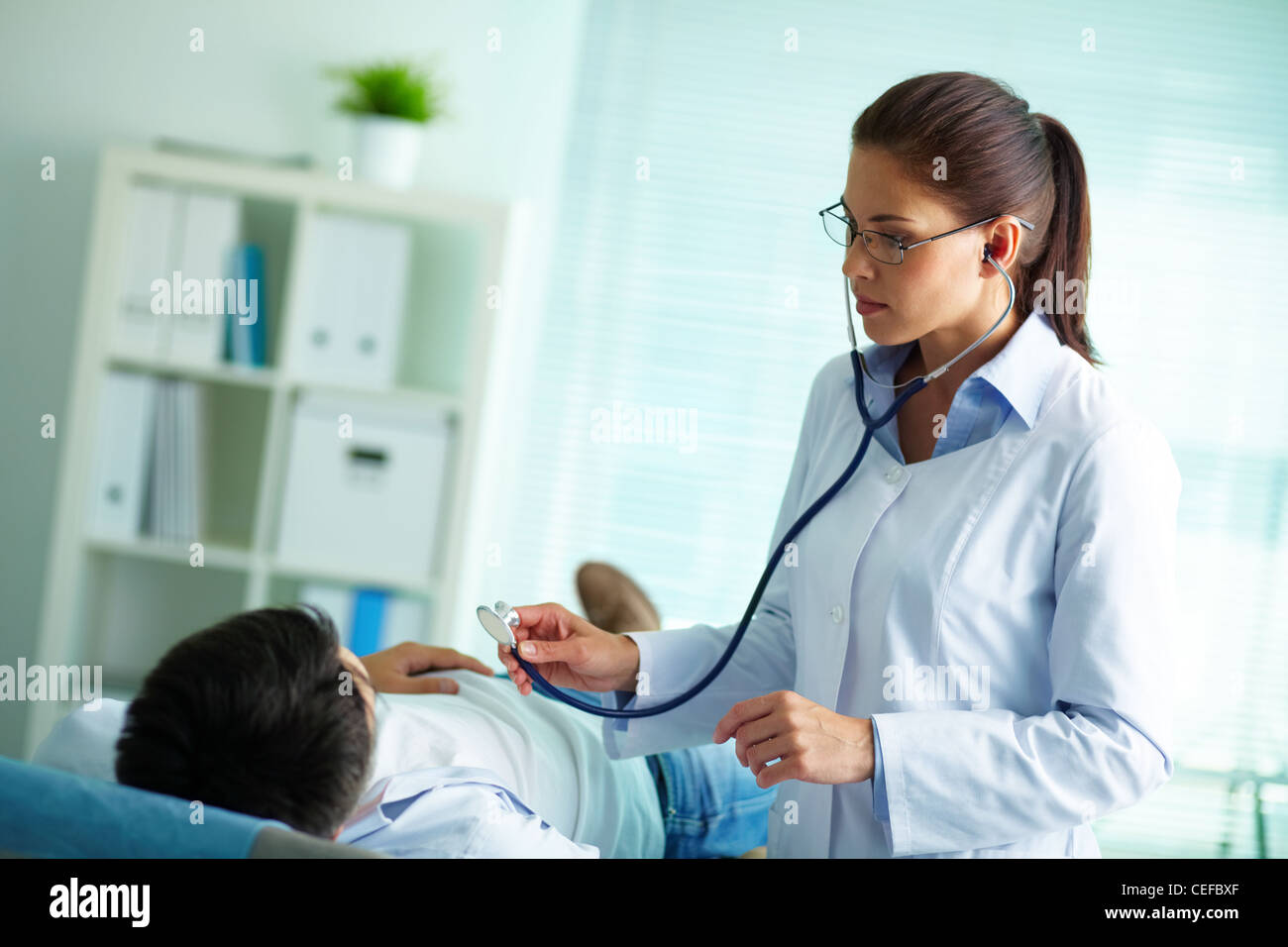 Portrait of confident female doctor looking at patient during medical ...