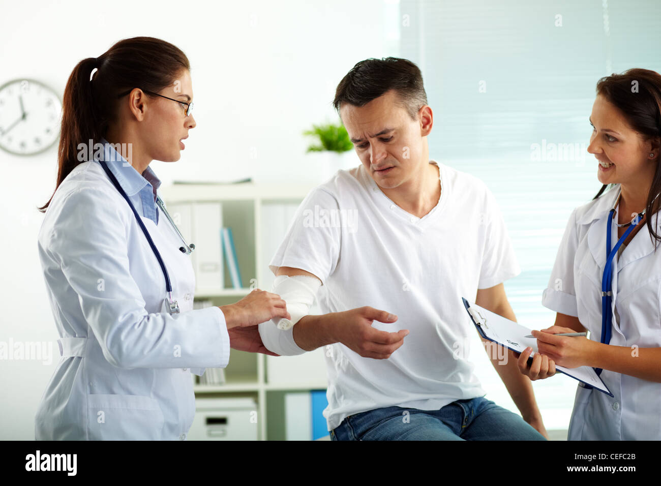 Portrait of confident female doctor giving first aid to patient in ...