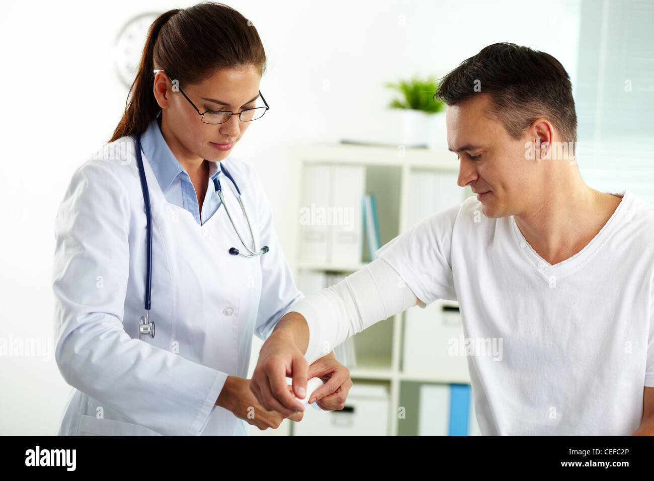 Portrait of confident female doctor giving first aid to male patient in ...